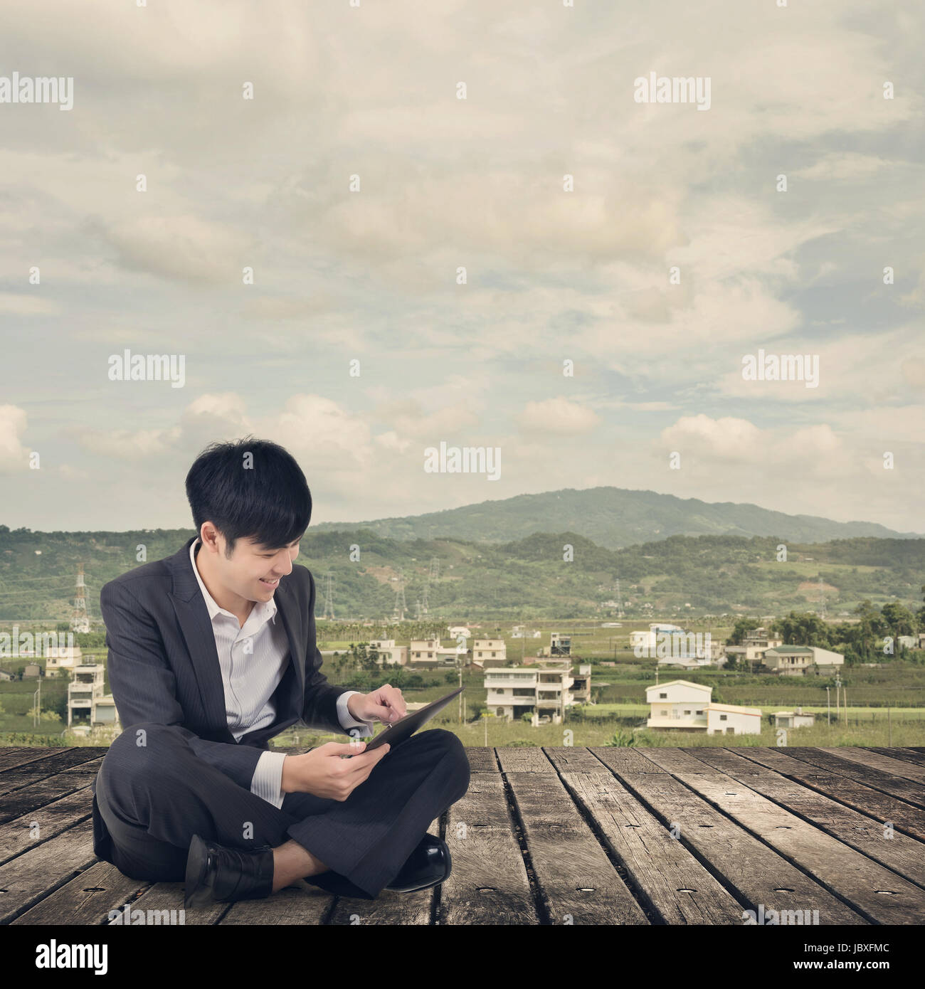 Asian business man using pad and sit on ground Stock Photo - Alamy