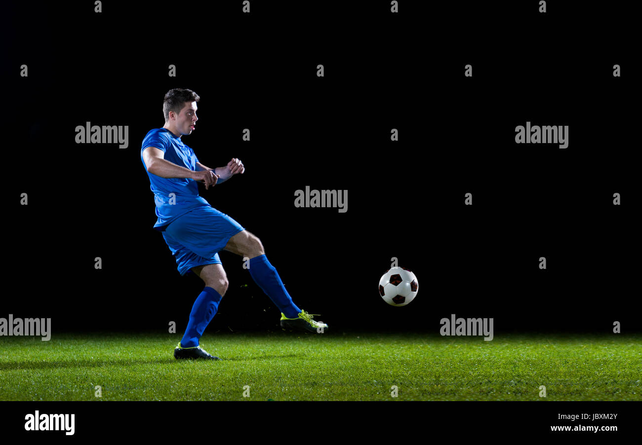 soccer player doing kick with ball on football stadium field isolated ...