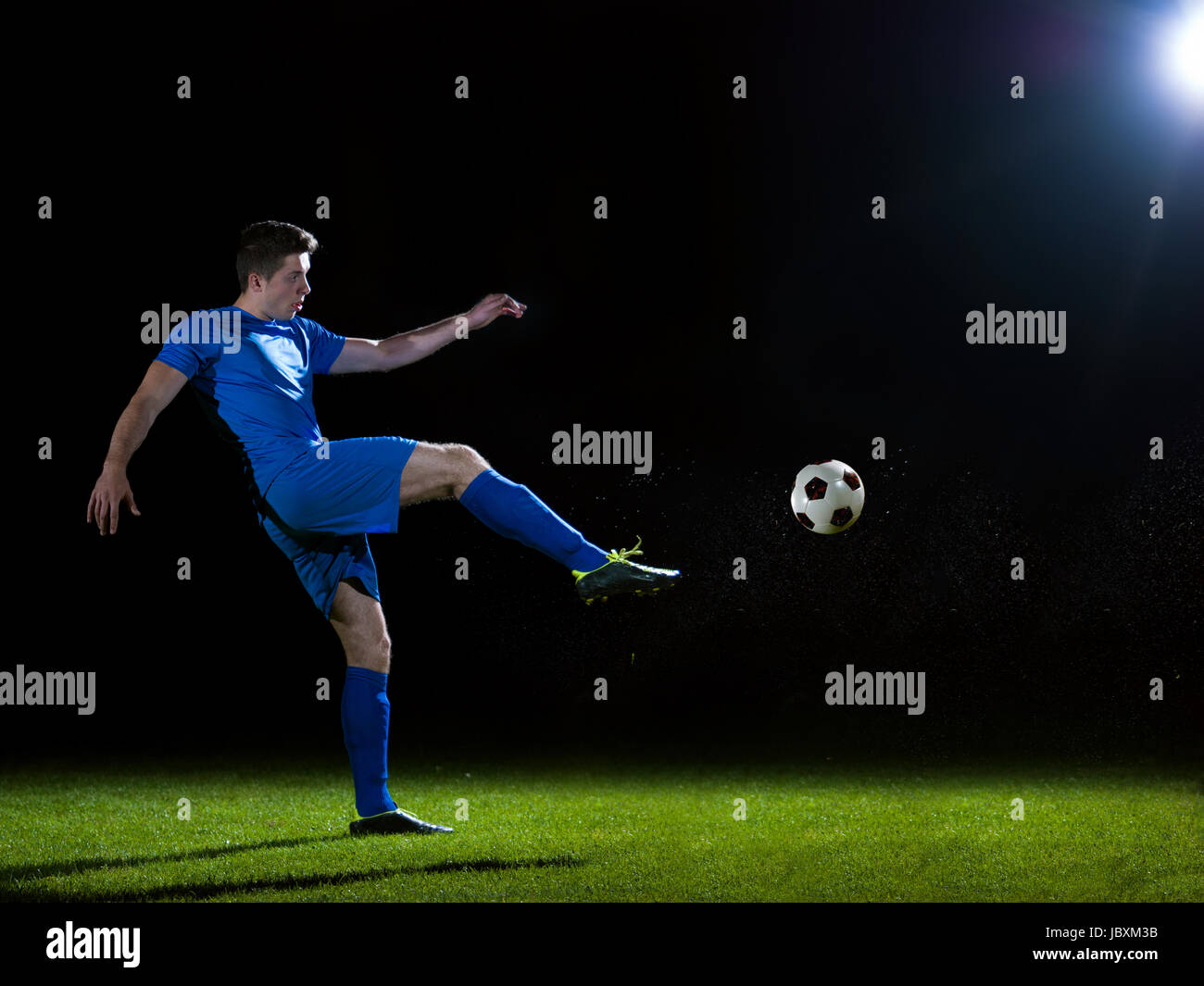 soccer player doing kick with ball on football stadium field isolated ...