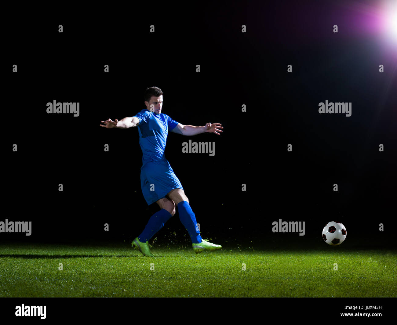 soccer player doing kick with ball on football stadium field isolated ...