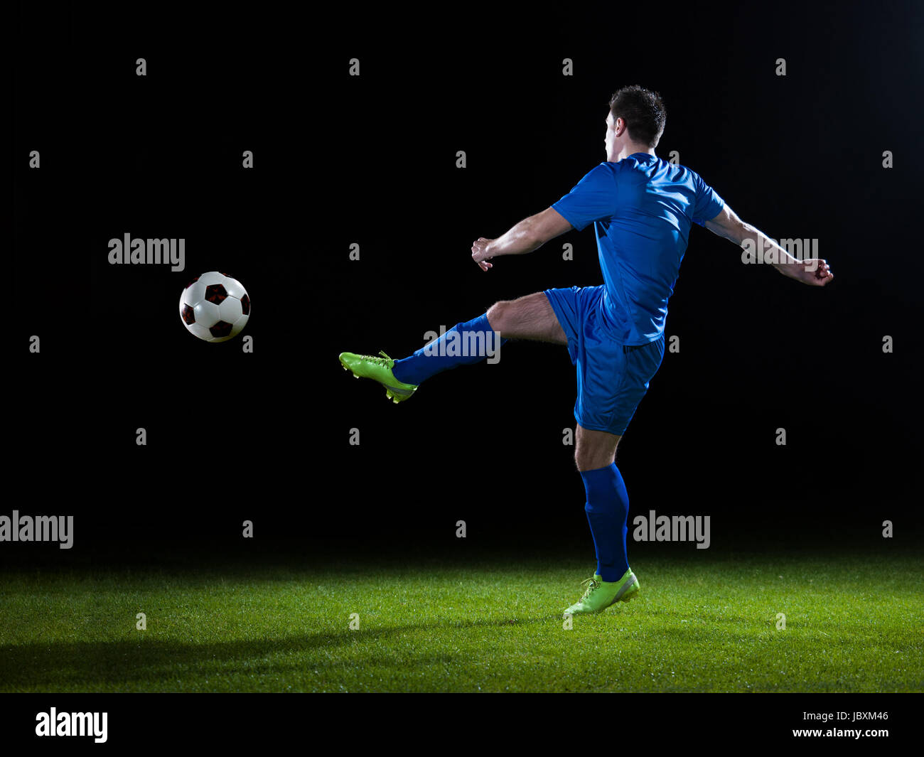 soccer player doing kick with ball on football stadium field isolated on black background Stock ...