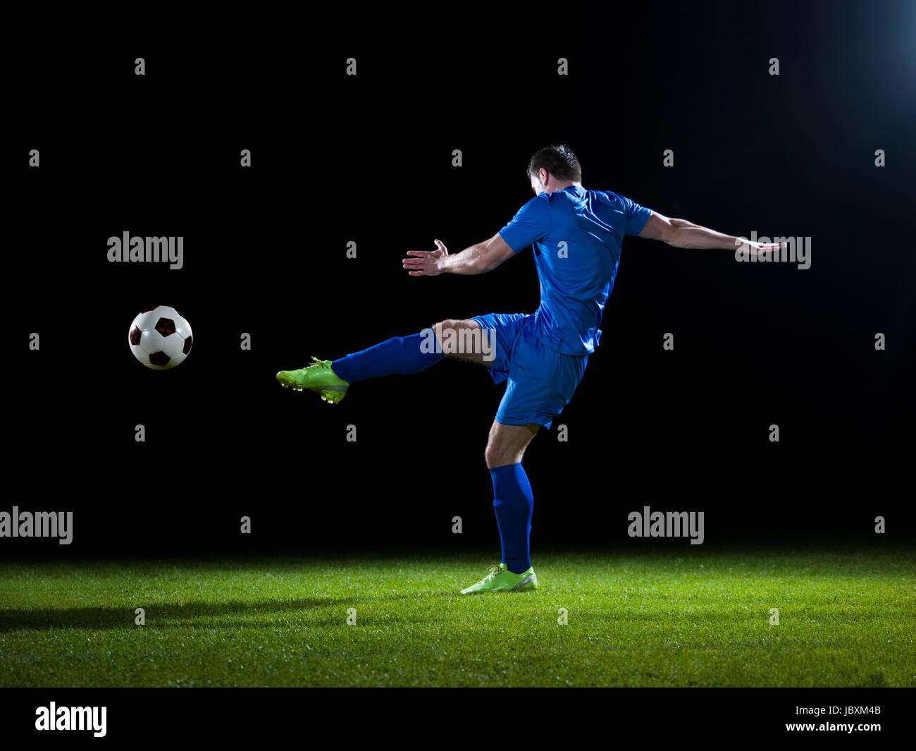 soccer player doing kick with ball on football stadium field isolated ...
