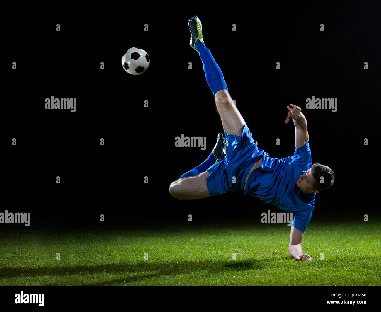 soccer player doing kick with ball on football stadium field isolated on black background Stock ...