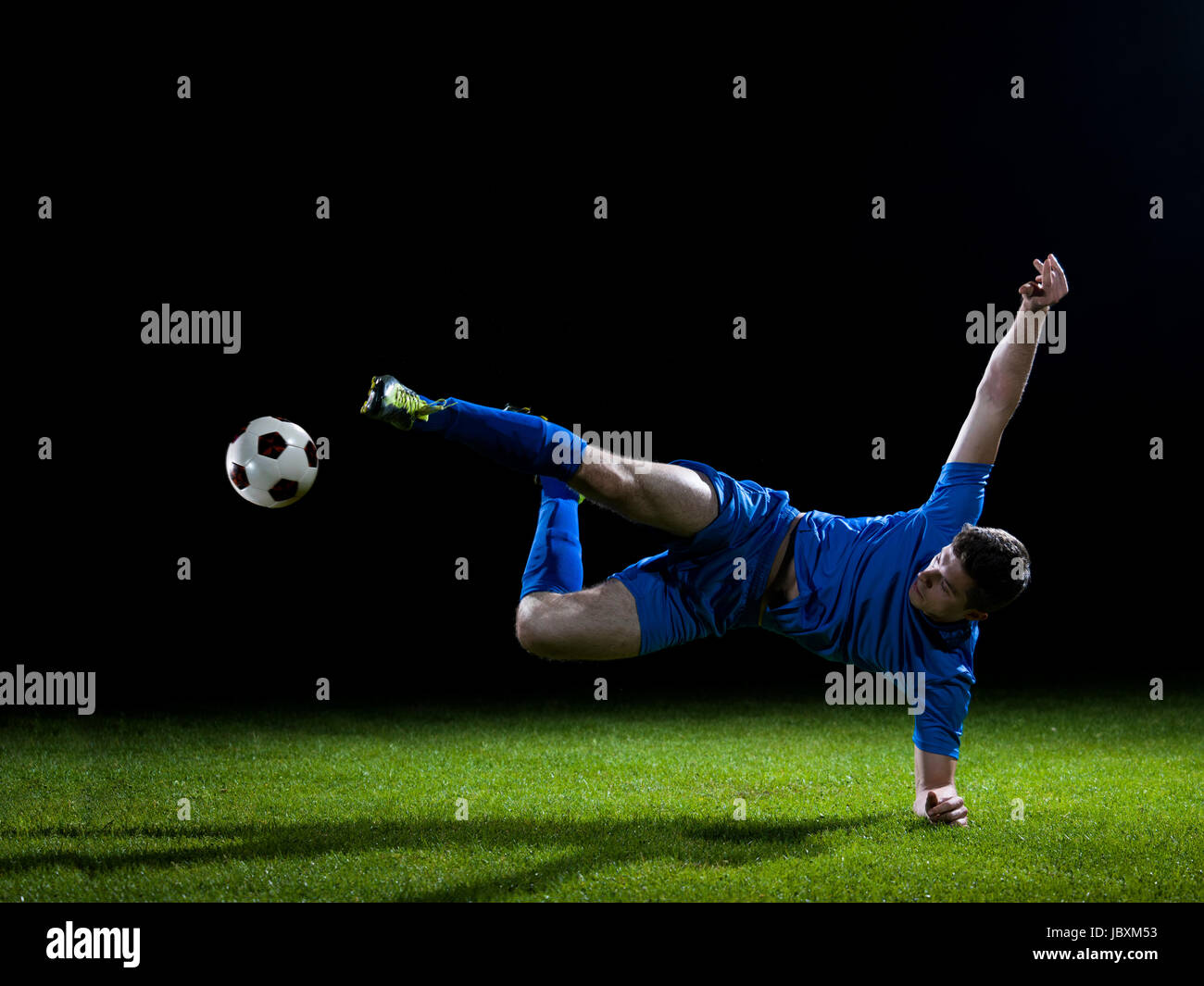 soccer player doing kick with ball on football stadium field isolated ...