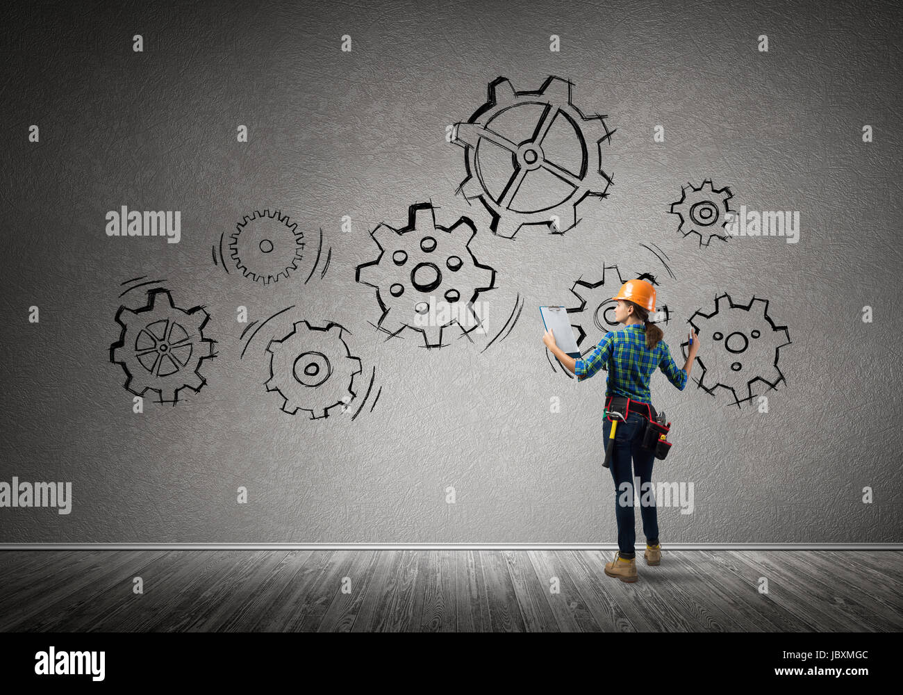 Back view of engineer woman in hardhat and sketched concept of teamwork ...