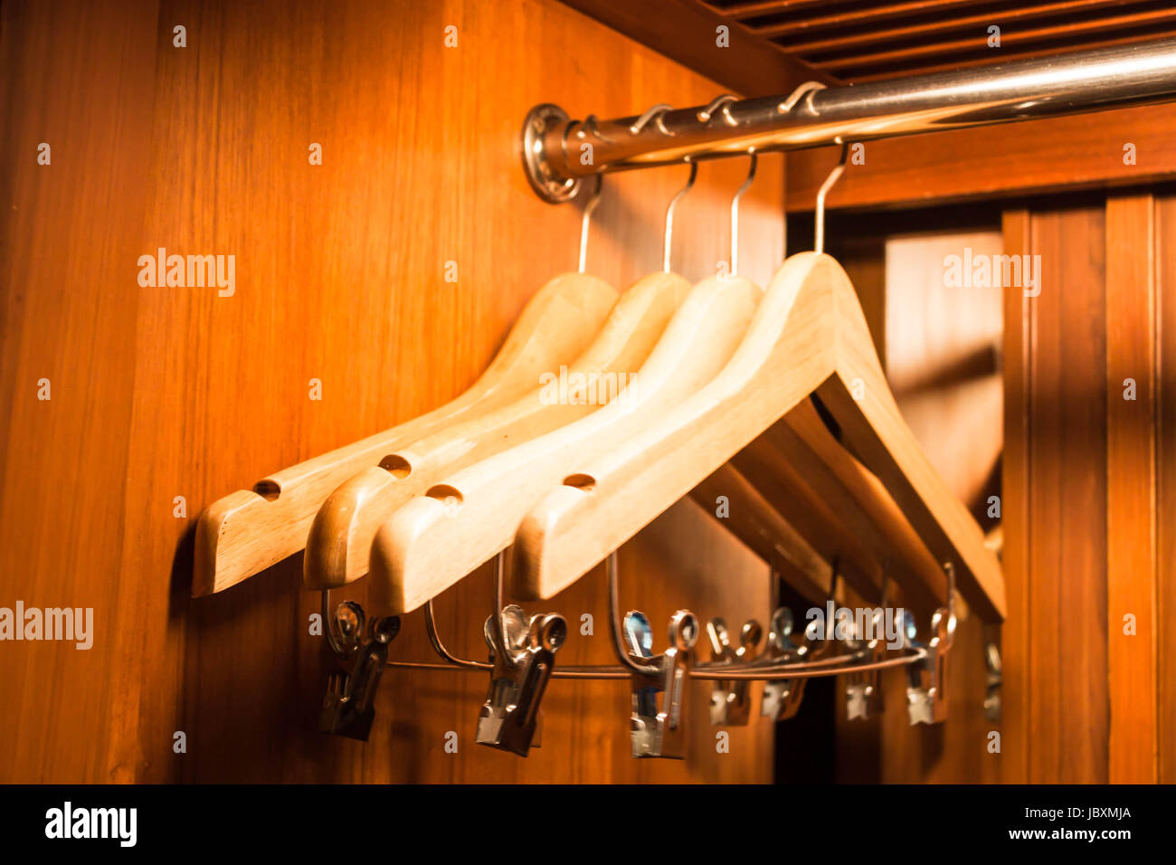 Wooden hanger hanging in an empty closet Stock Photo - Alamy