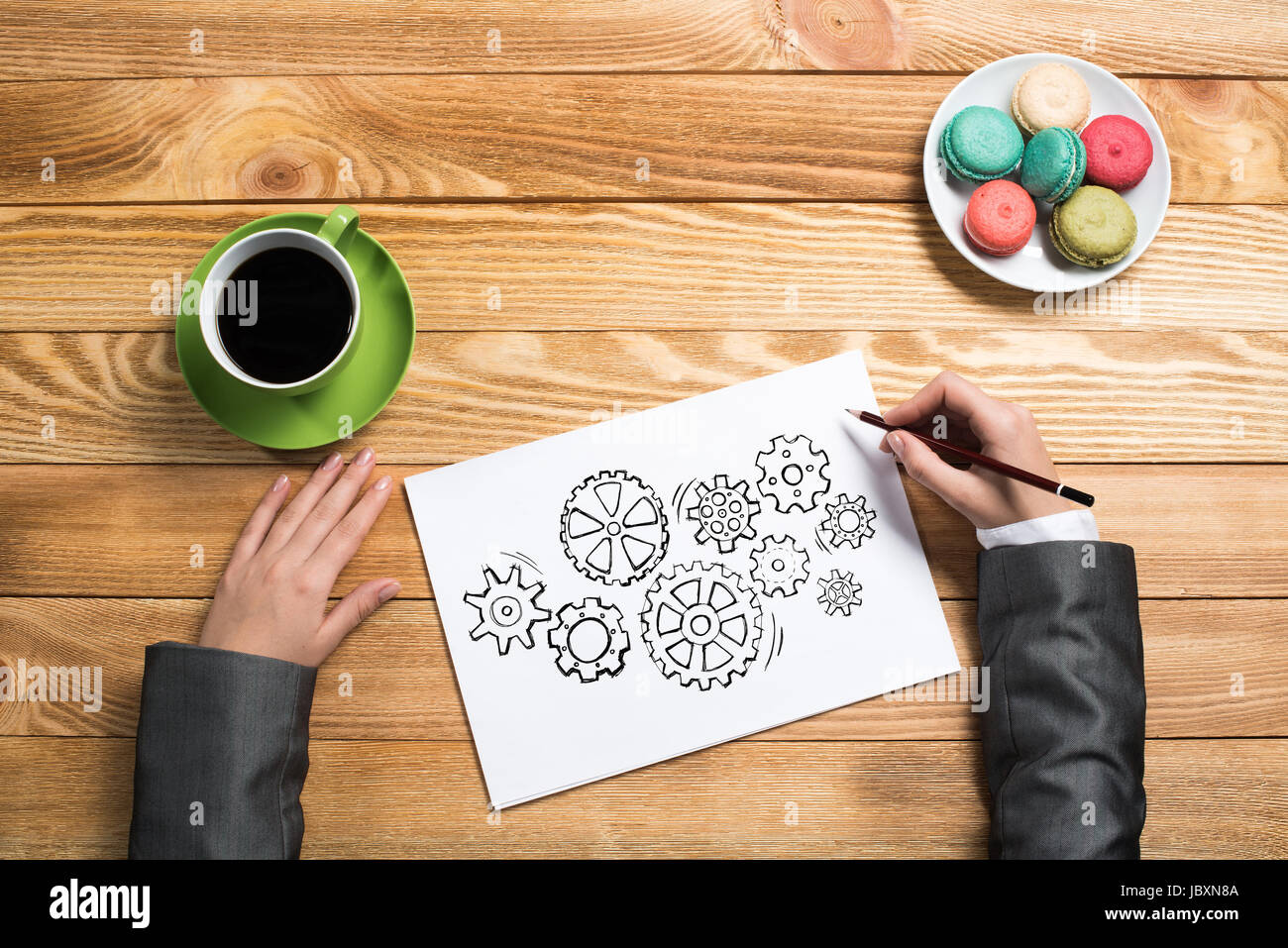 To view of businesswoman hands drawing on paper sheet gears mechanism ...