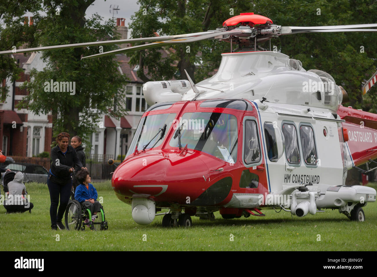 Local residents look closely at an AgustaWestland AW139 helicopter ...