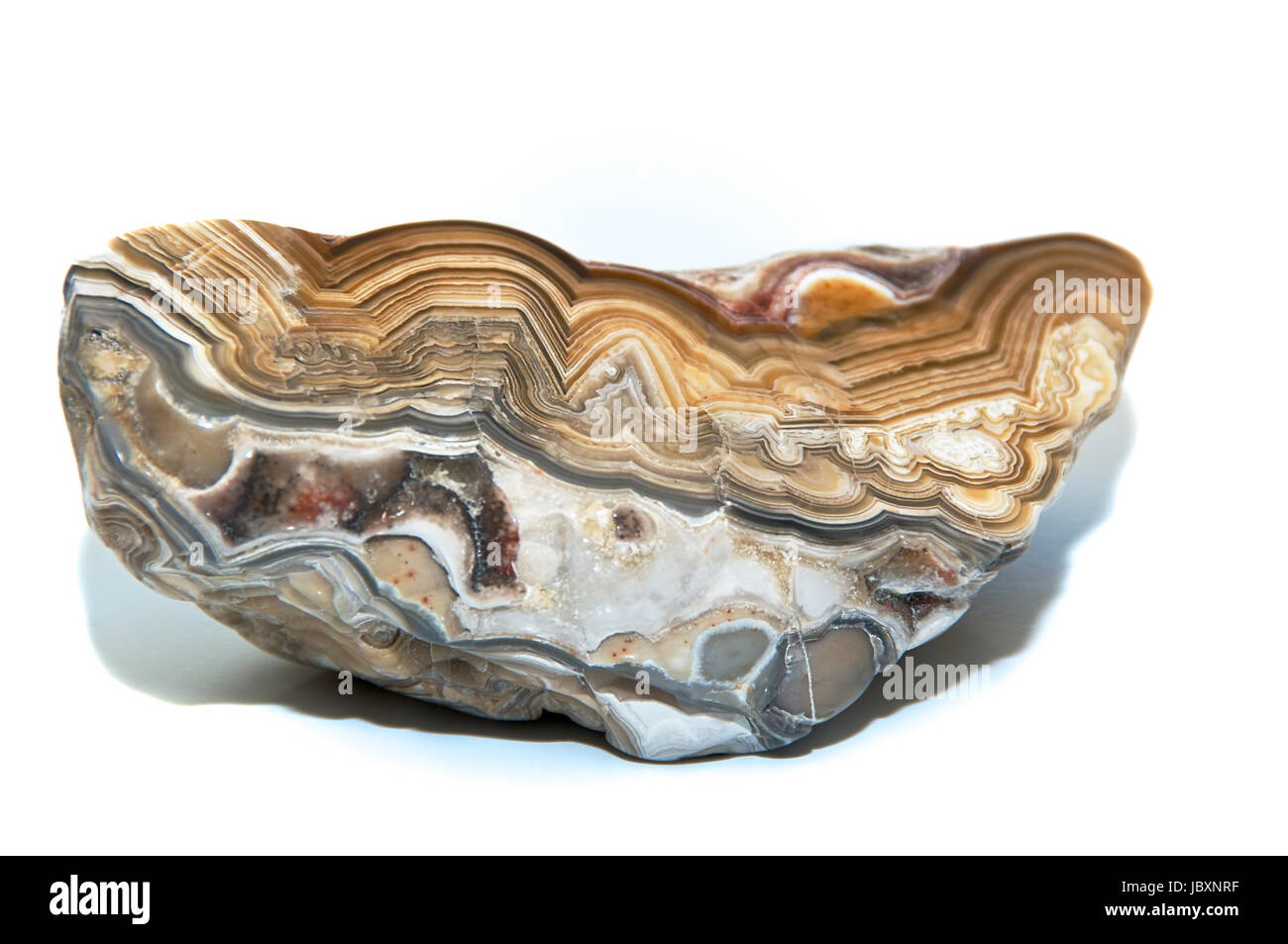 A layers and colorful cut and polished stone over white showing the ...