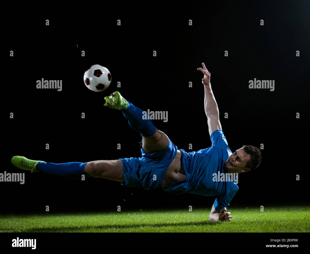 soccer player doing kick with ball on football stadium field isolated ...