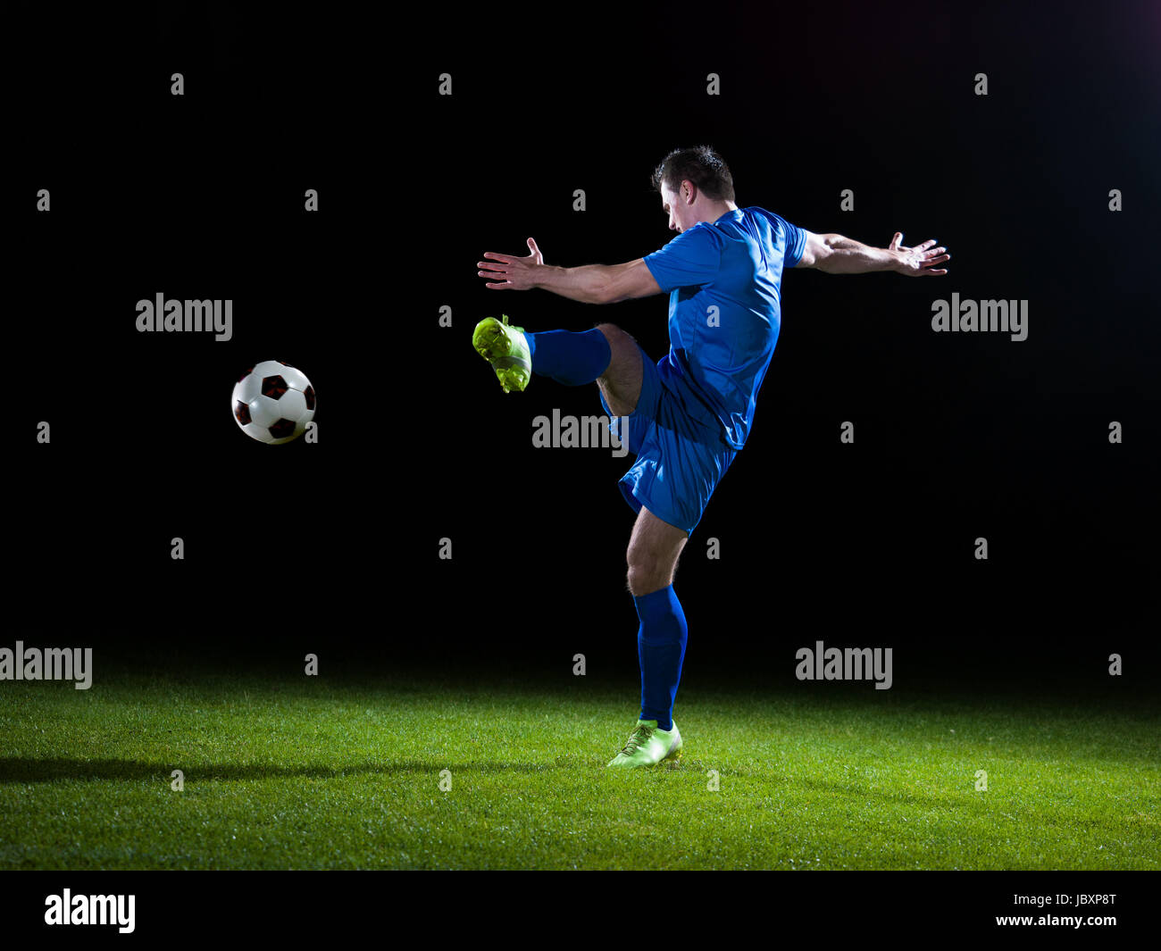 soccer player doing kick with ball on football stadium field isolated ...