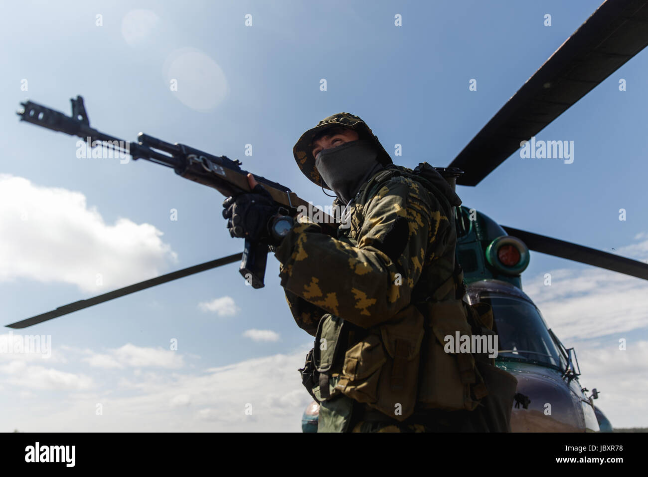 Photo of a soldier with an automatic rifle at a helicopter Stock Photo ...