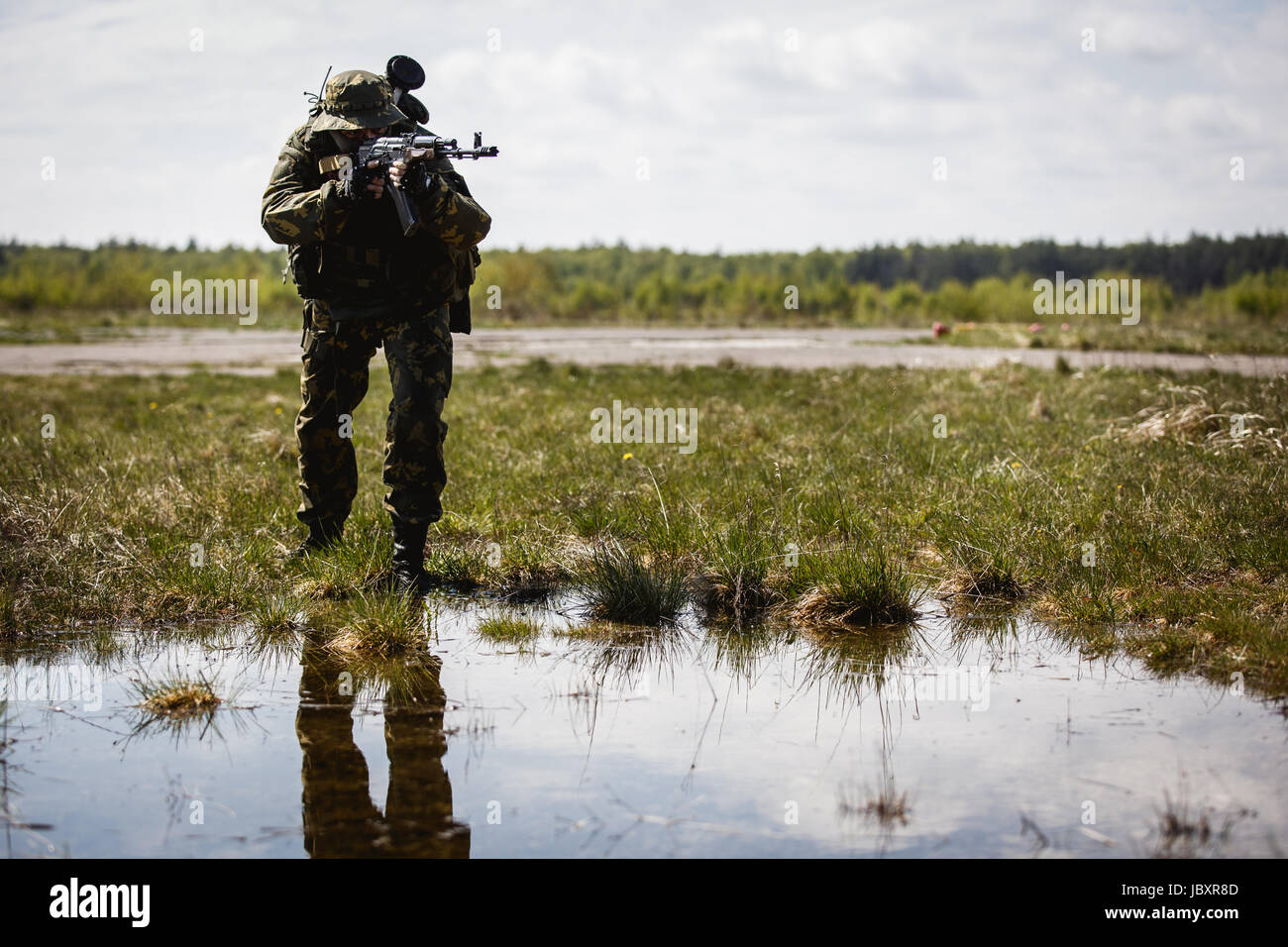 Photo of military man with gun in field during day Stock Photo - Alamy