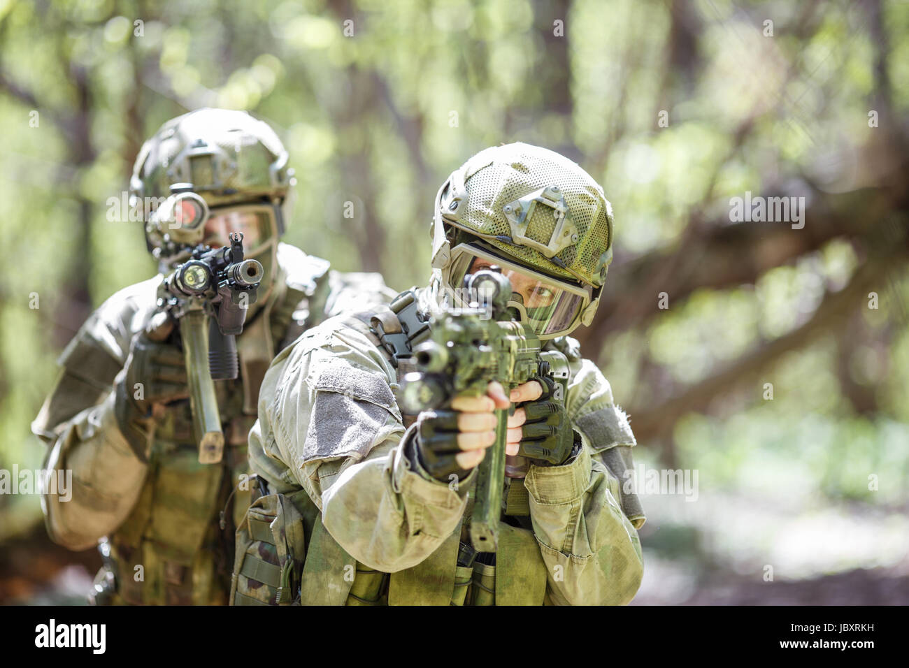 Two men with arms on military operation in forest Stock Photo - Alamy
