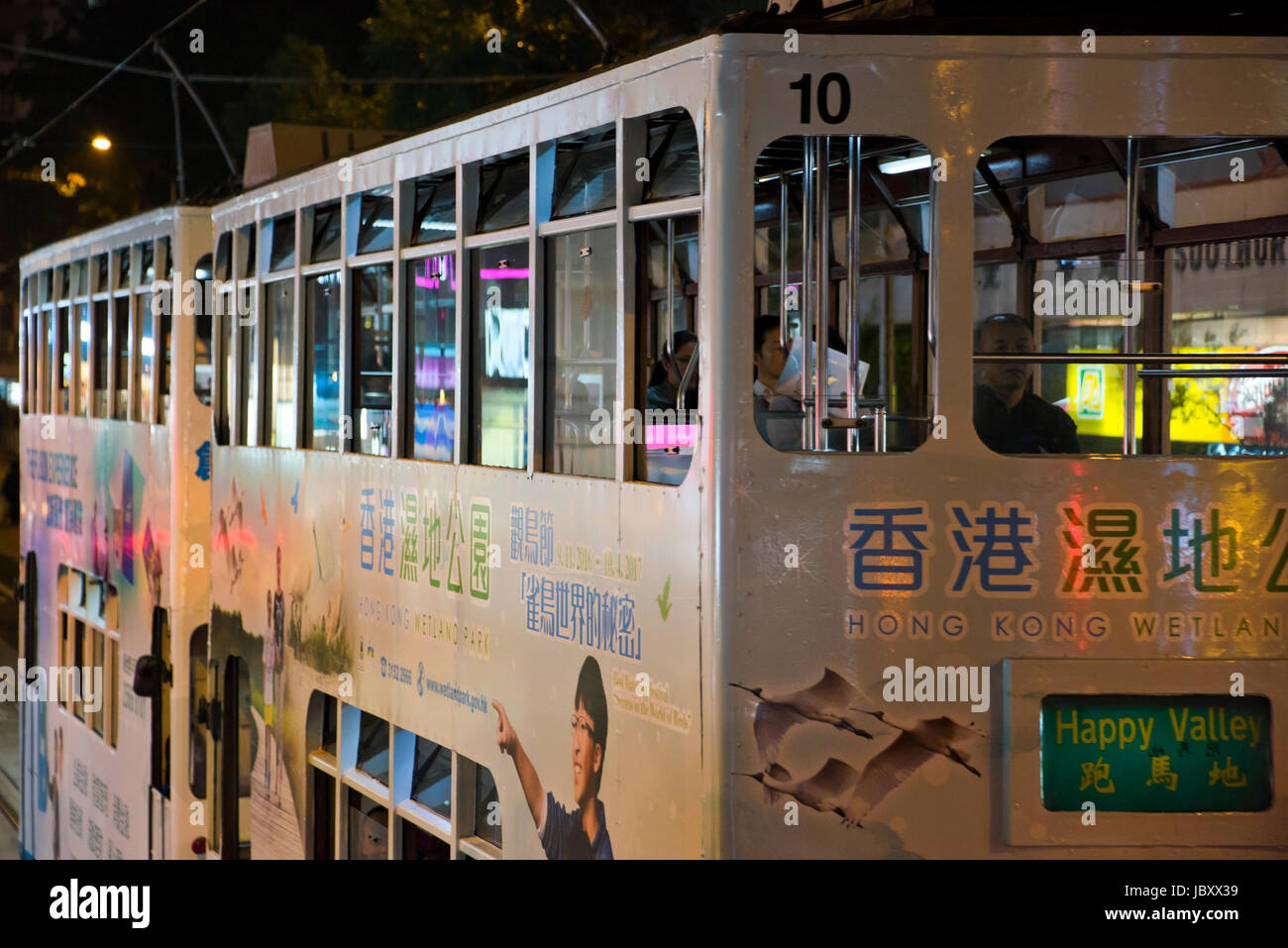 Horizontal view of the traditional old trams at night in Hong Kong ...