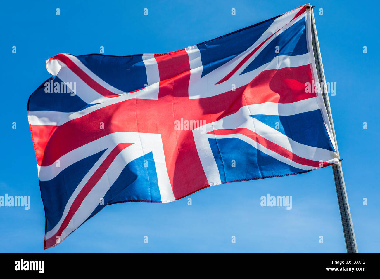A Union Flag flying proudly under a clear blue sky Stock Photo - Alamy
