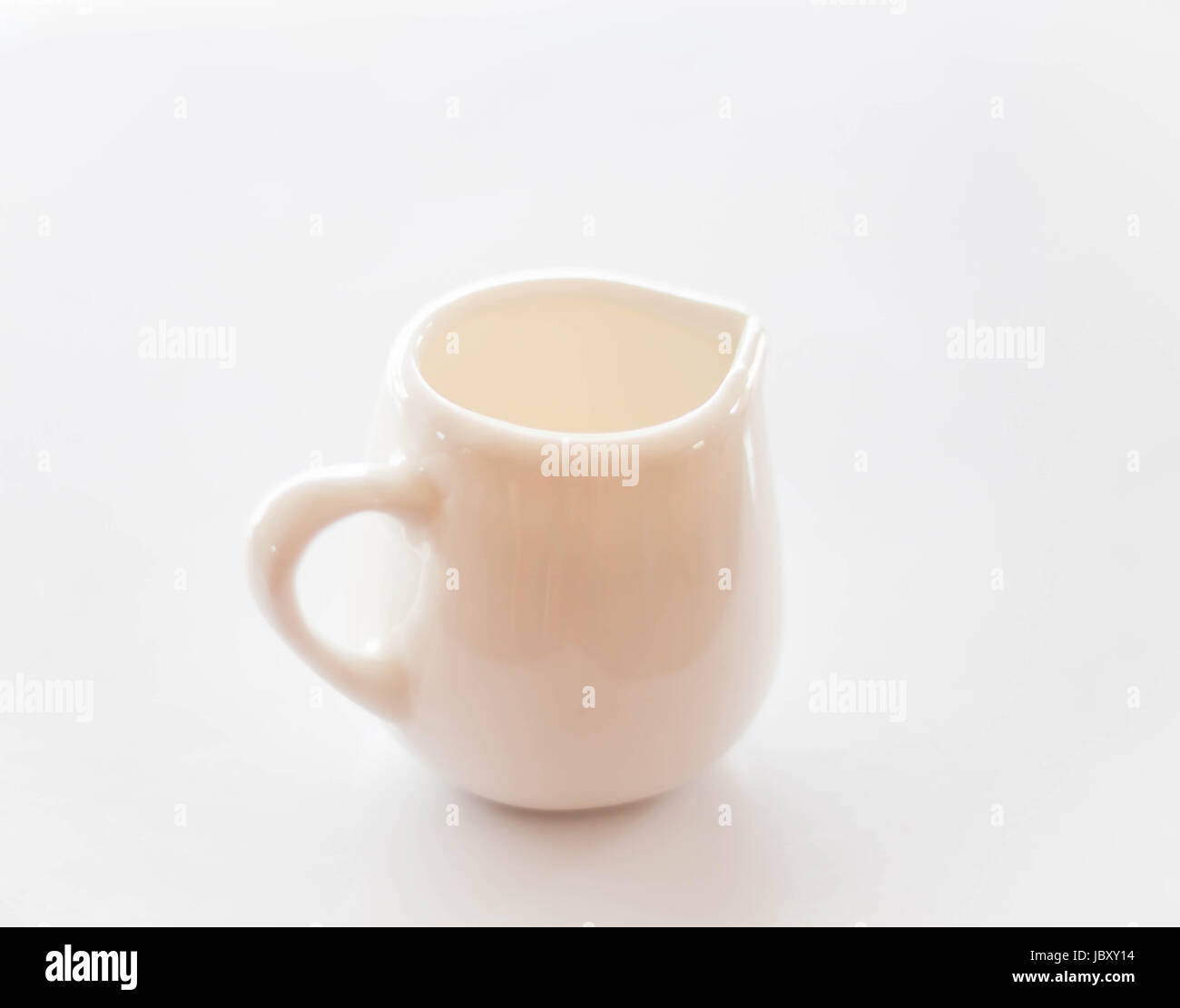 White ceramic pitcher for milk on clean table Stock Photo - Alamy