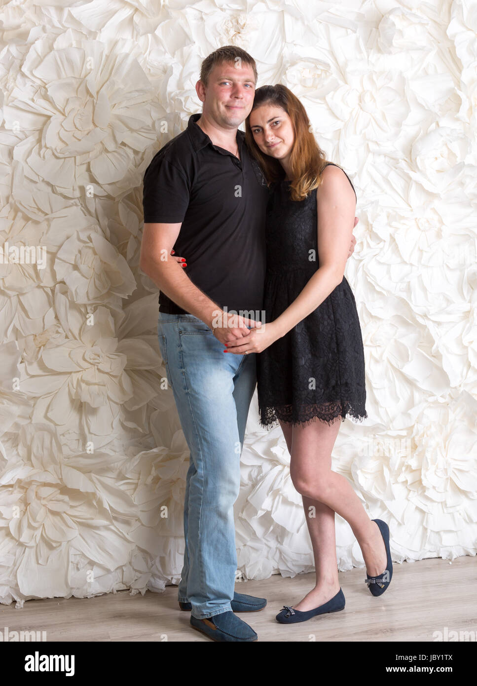 Full length studio portrait of embracing happy young wife and husband ...