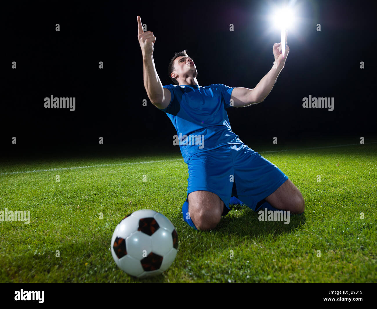 soccer player doing kick with ball on football stadium field isolated ...