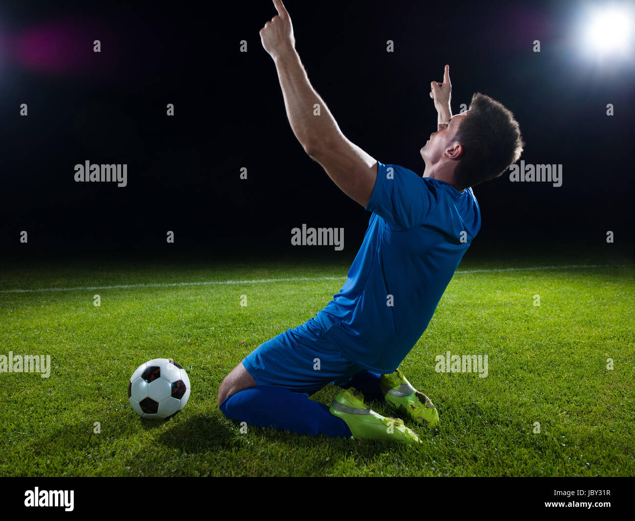 soccer player doing kick with ball on football stadium field isolated ...