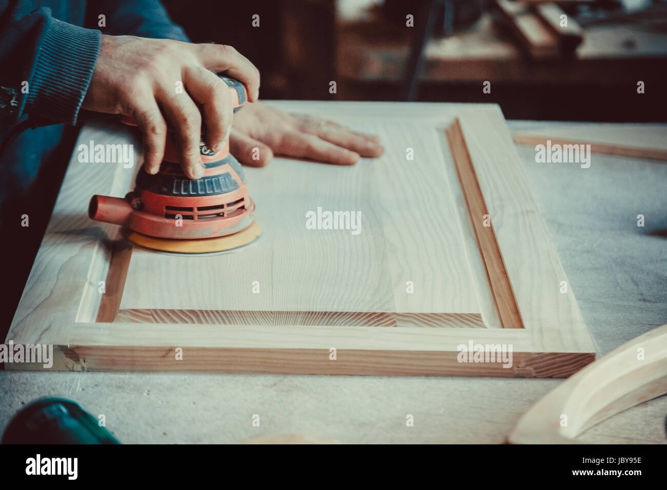Close-up of carpenter using sander for wood furniture. Soft focus ...