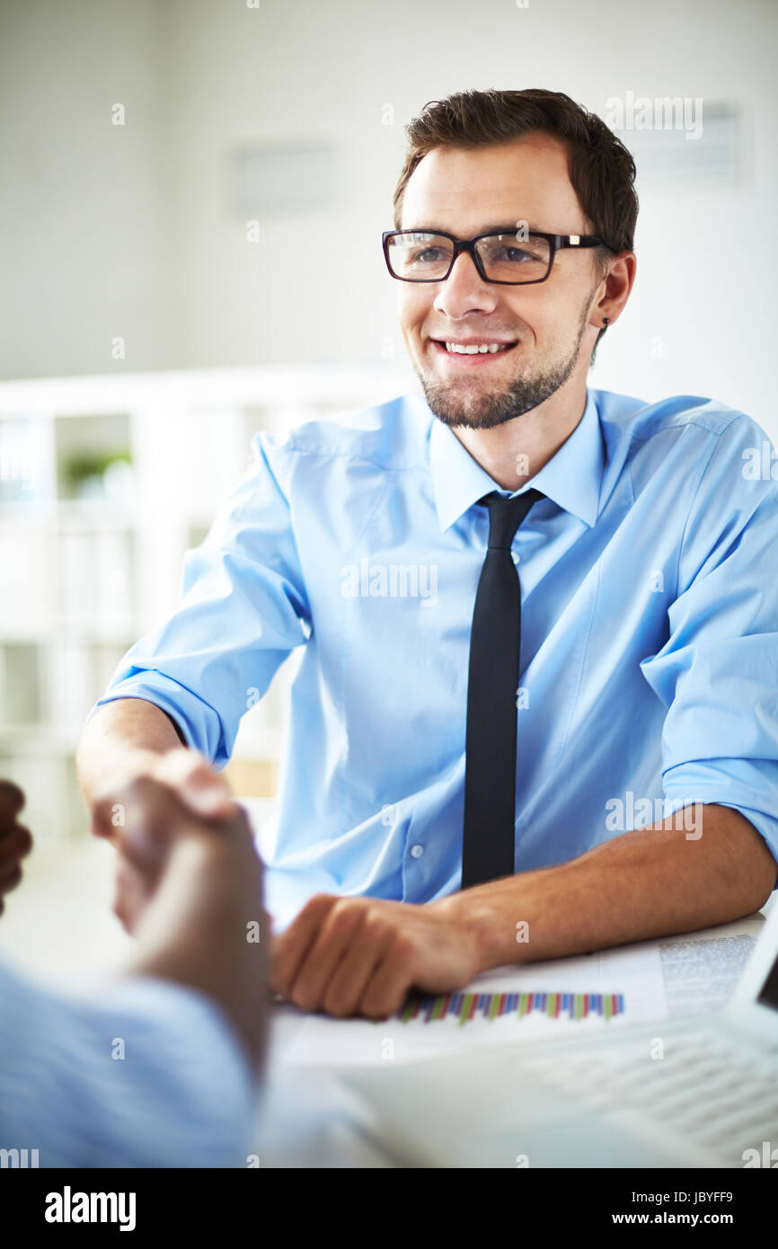 Smiling businessman handshaking with partner after negotiations Stock ...