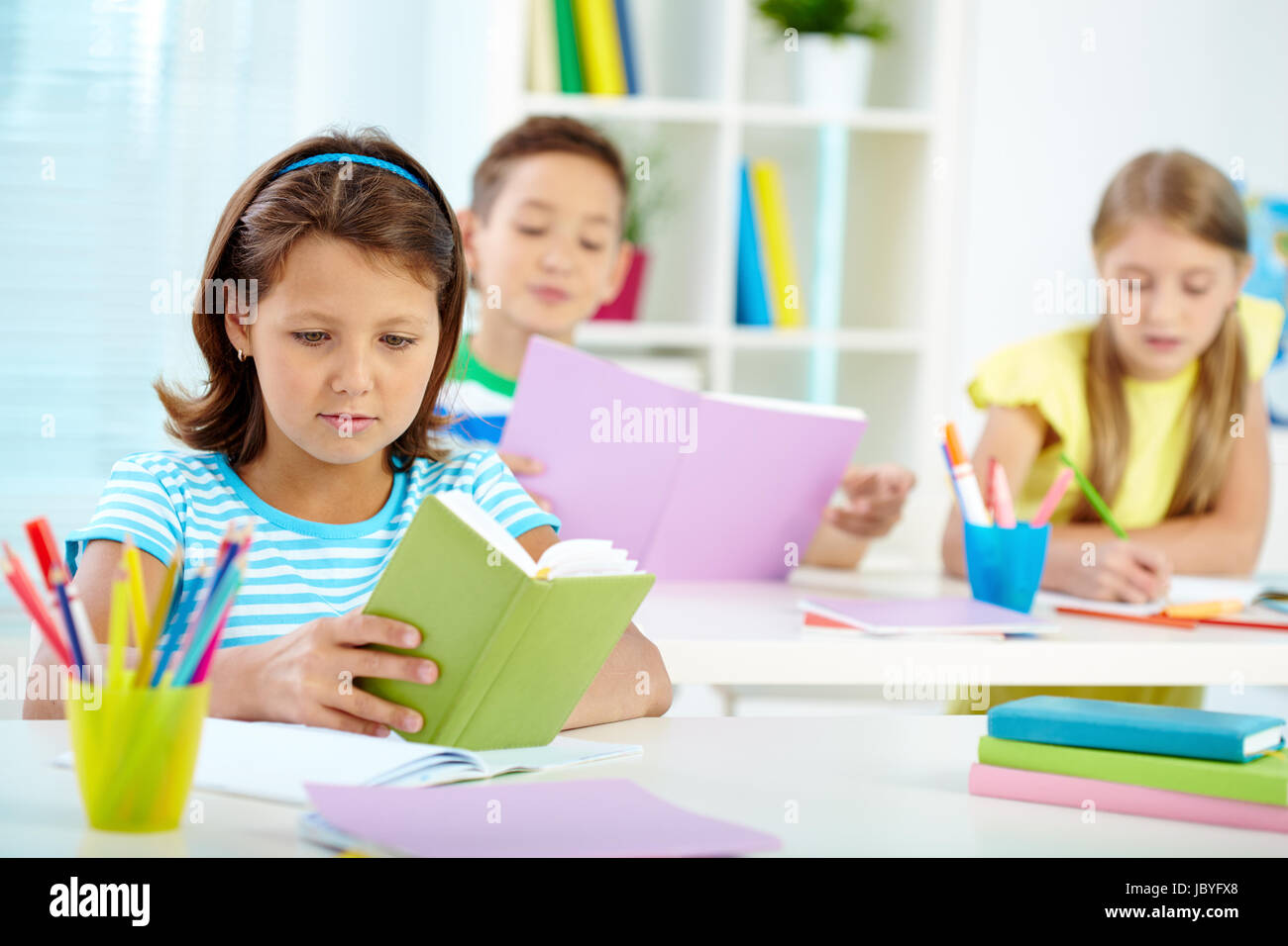 Portrait of serious girl with notepad reading notes on background of ...
