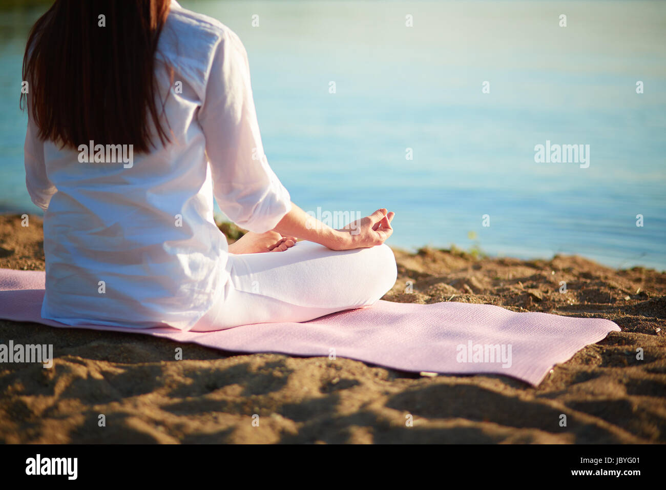 Back of meditating woman relaxing in pose of lotus outdoors Stock Photo ...