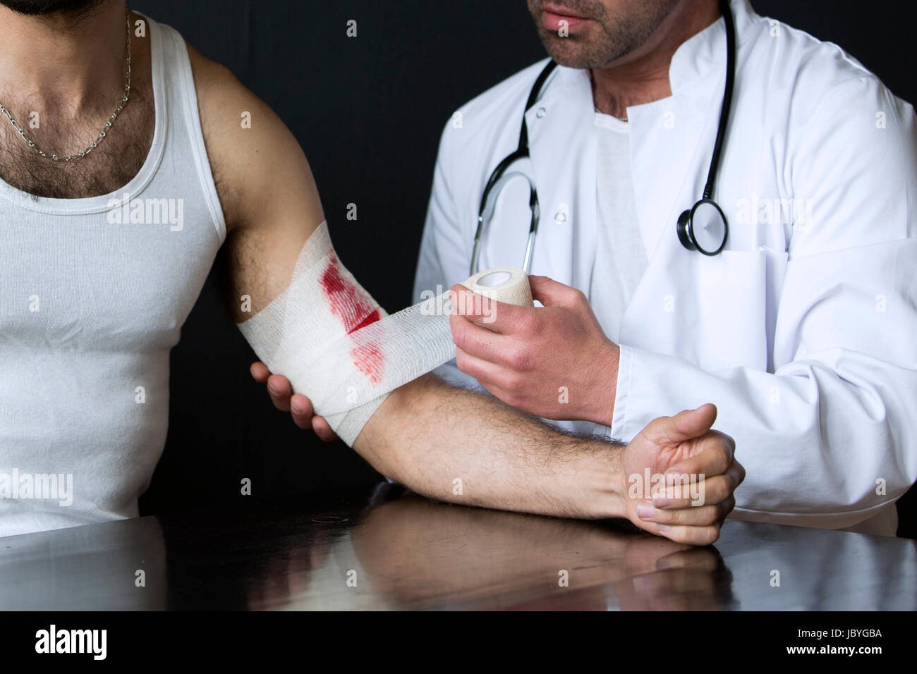 closeup of man with bloody wound getting a bandage from doctor Stock ...
