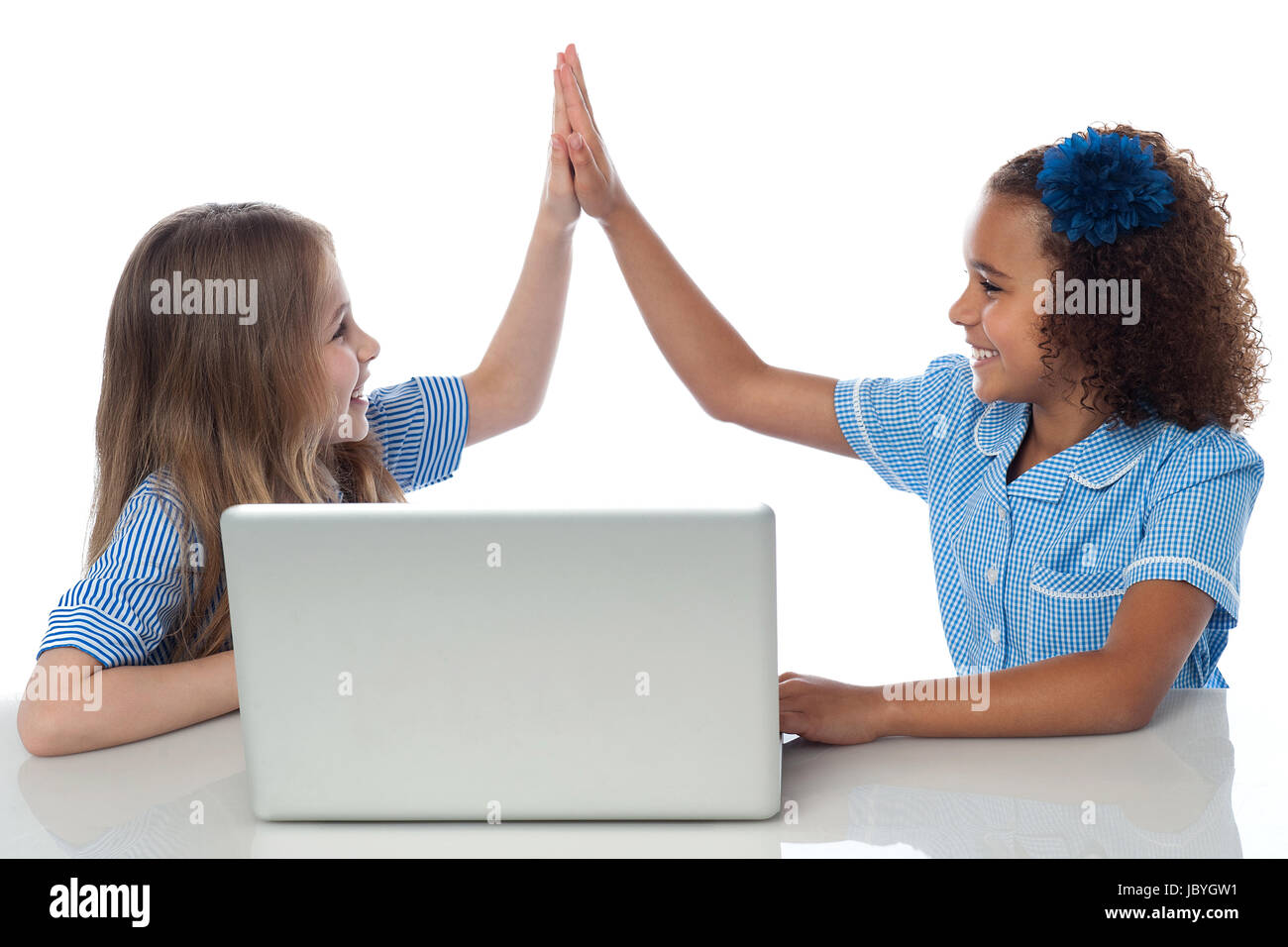 School girls giving high five with laptop Stock Photo - Alamy