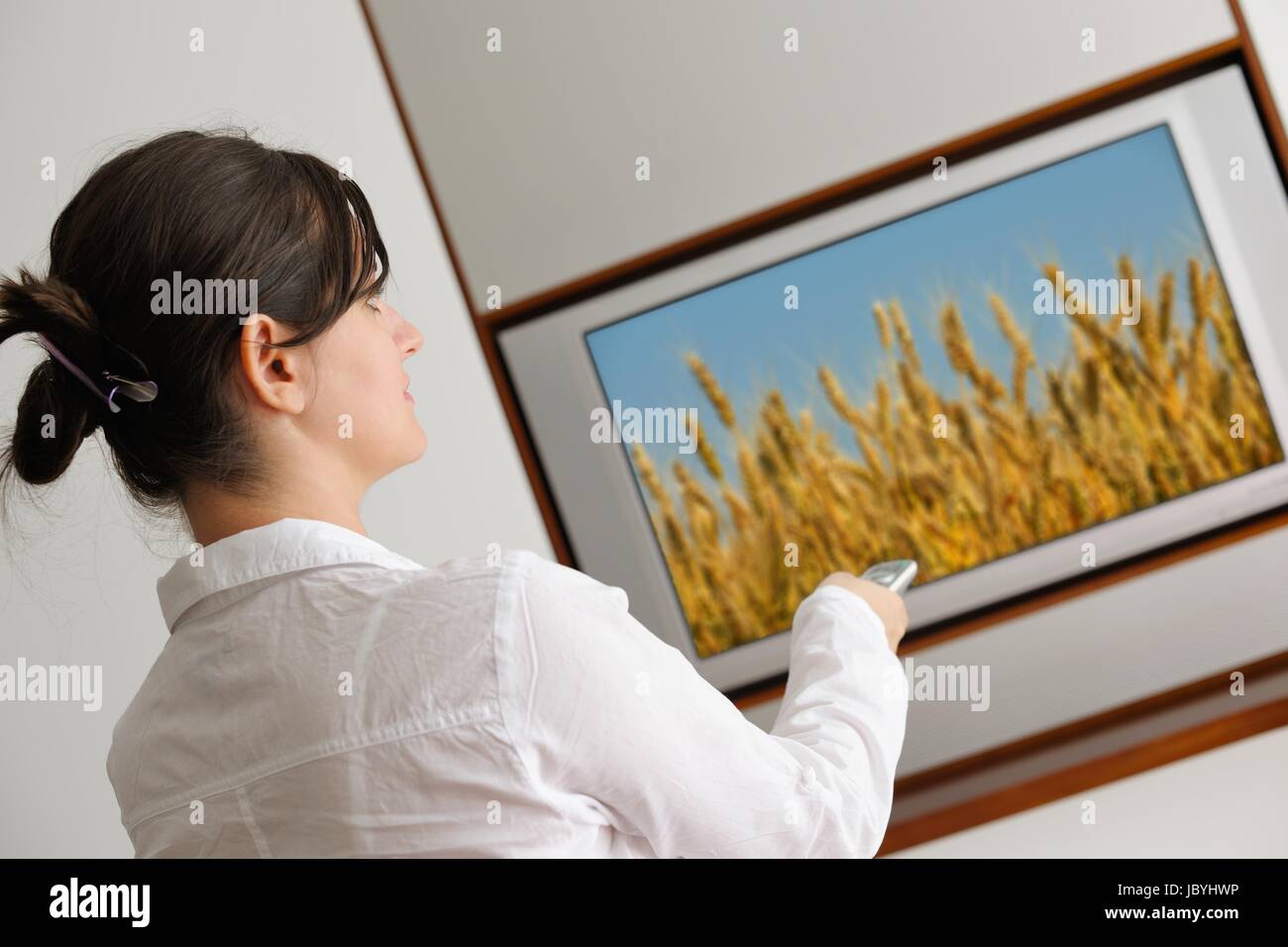 happy young woman watching tv at modern home livingroom Stock Photo - Alamy