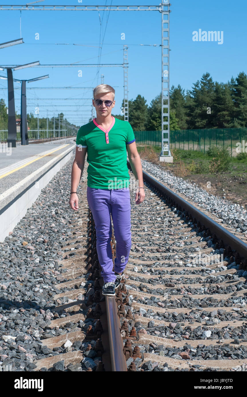 Trendy young men walking on the rail track Stock Photo - Alamy