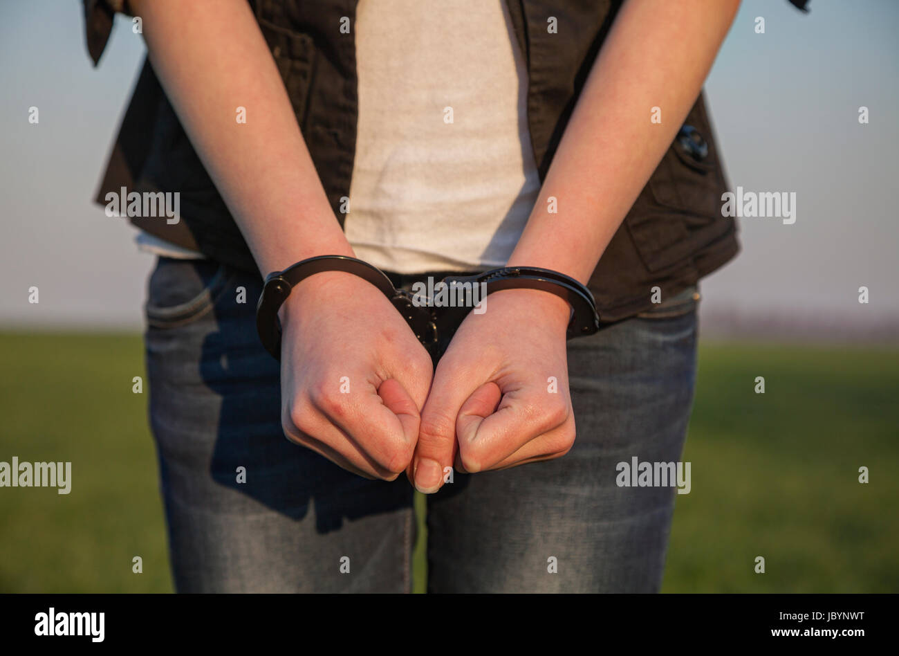 Handcuffed woman's hands outdoors Stock Photo - Alamy