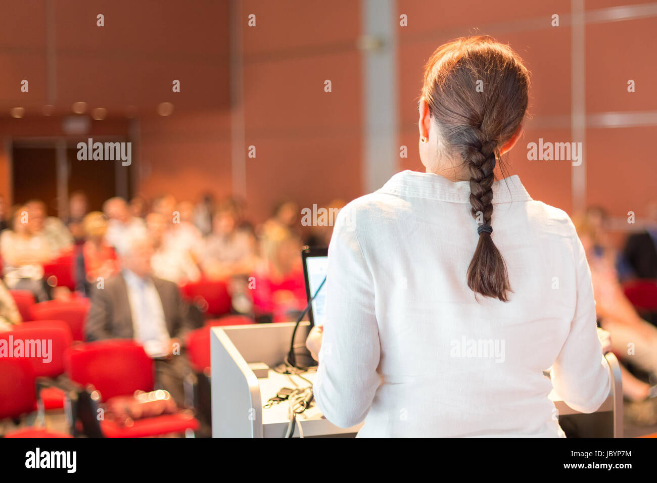 Female academic professor lecturing at Conference. Audience at the ...