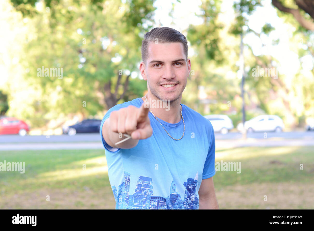 Portrait of young latin man pointing to camera at the park Stock Photo ...