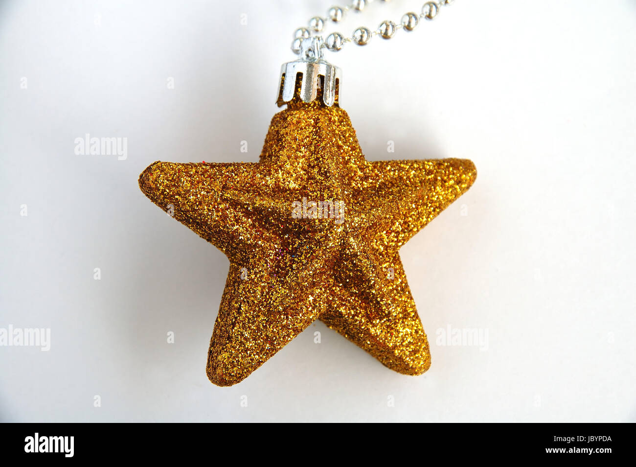 A yellow ornamental christmas star with white background Stock Photo ...