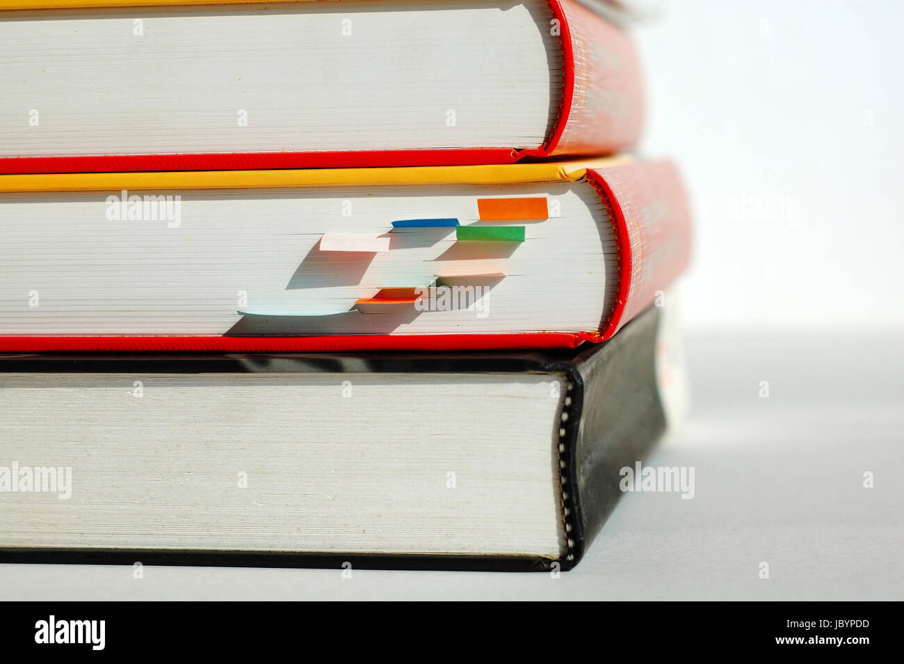 Three books are piled together, and the middle one is with markers ...