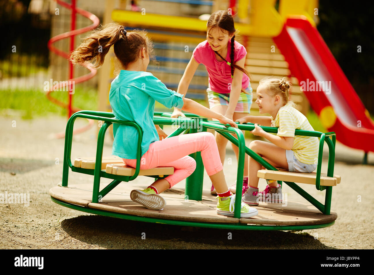 Image of joyful friends having fun on carousel outdoors Stock Photo - Alamy