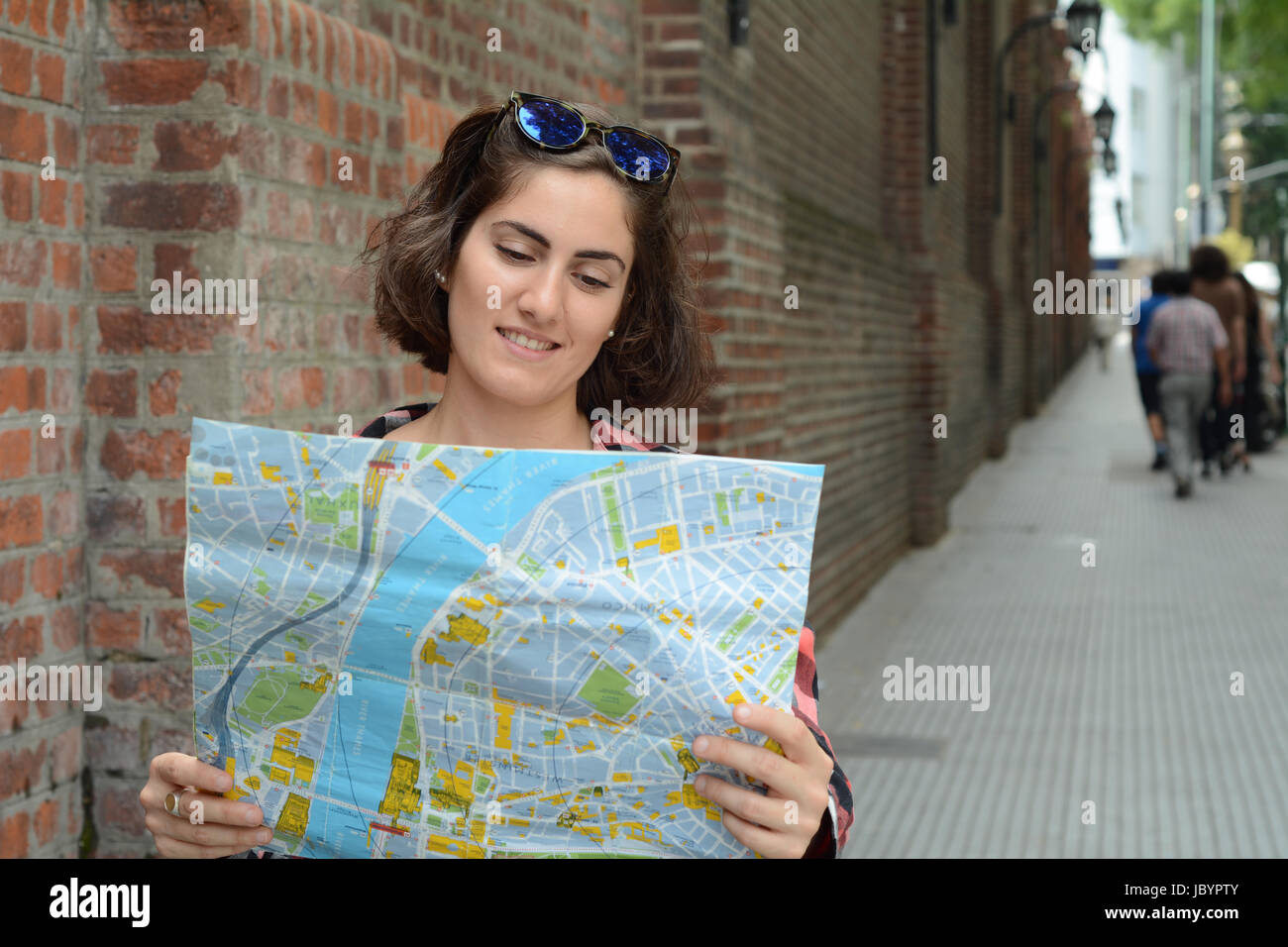 Portrait of a young beautiful tourist looking at a map. Tourism concept ...