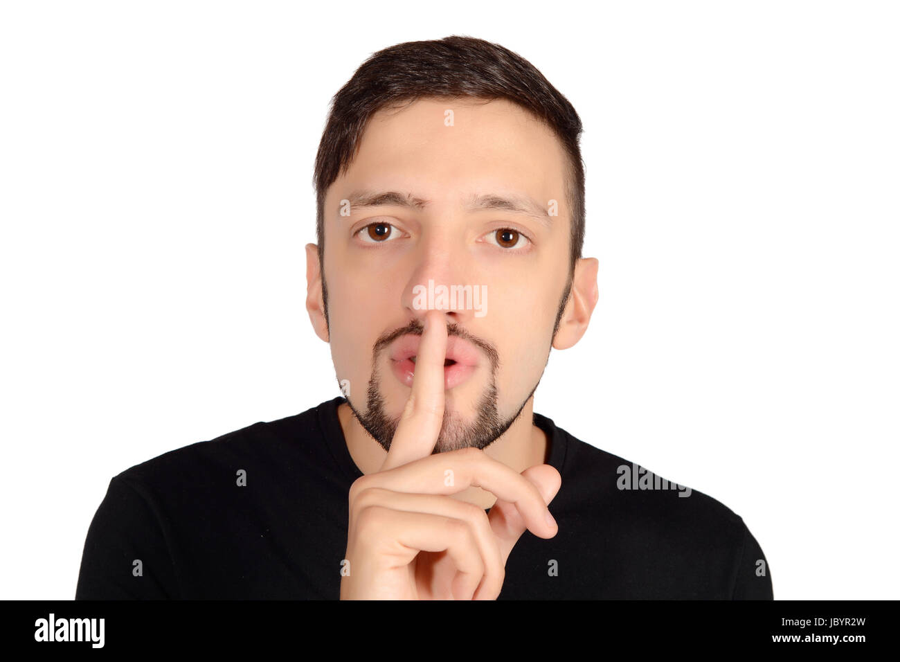 Portrait of a young man with finger on lips making silence. Isolated ...
