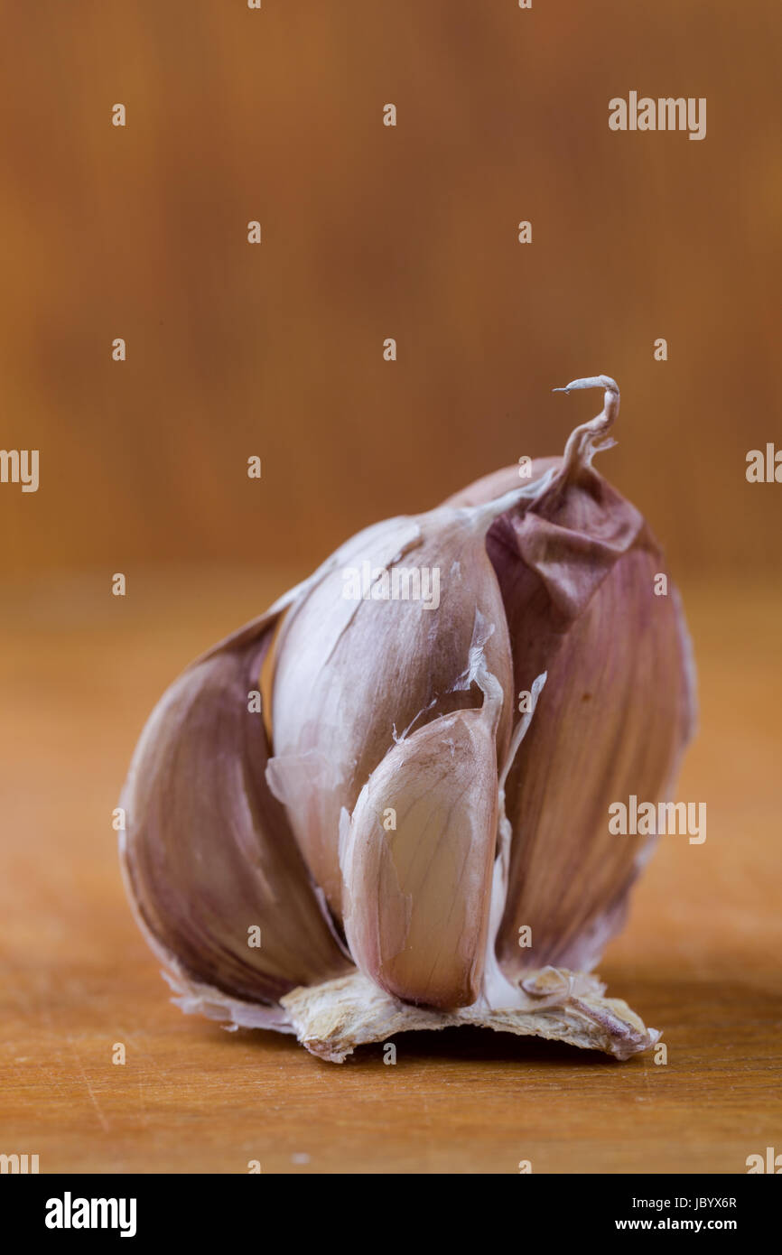 cloves of garlic on scratched yellow wooden background Stock Photo - Alamy