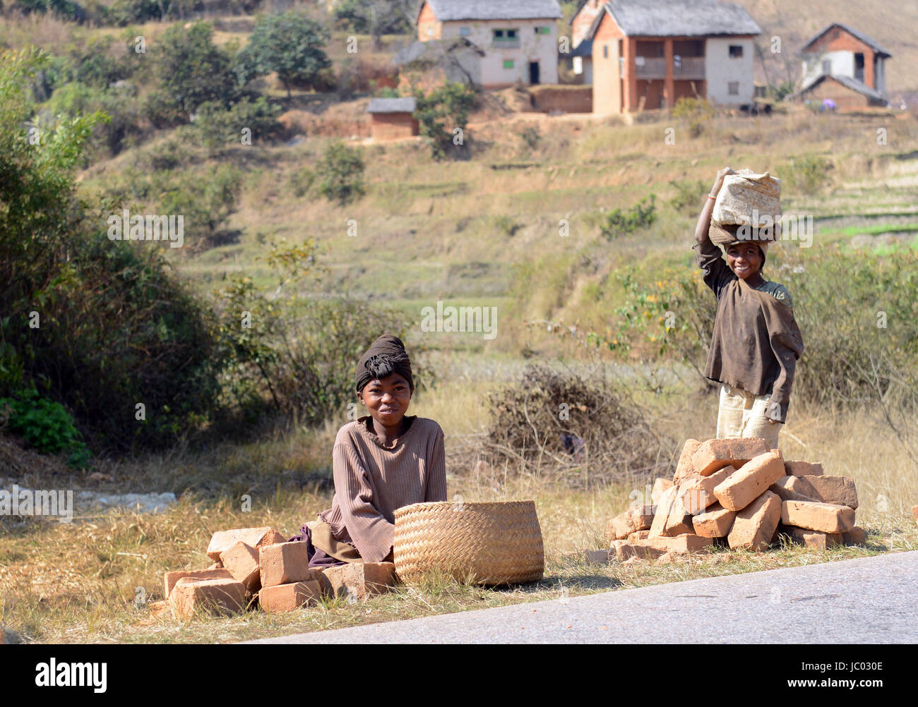 Children carrying heavy bricks in rural Madagascar Stock Photo - Alamy