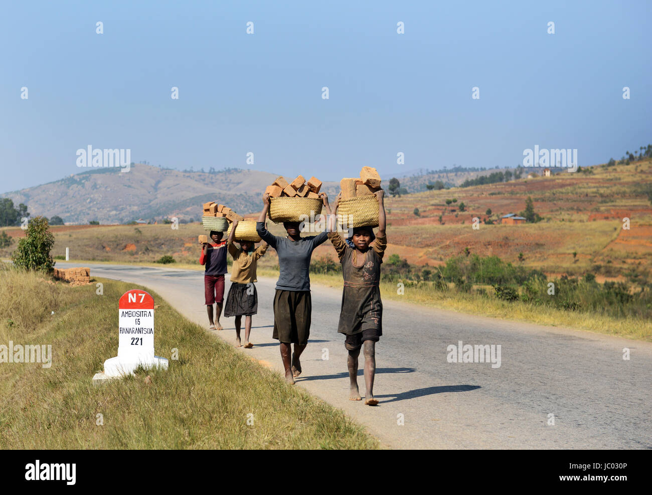 Children carrying heavy bricks in rural Madagascar Stock Photo - Alamy