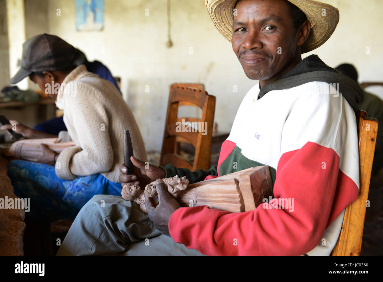A Malagasy artist working on his wood sculpture Stock Photo - Alamy