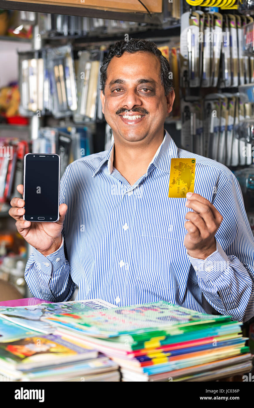 1 Indian Shop Keeper Man Showing Credit Card And Mobile Phone In ...