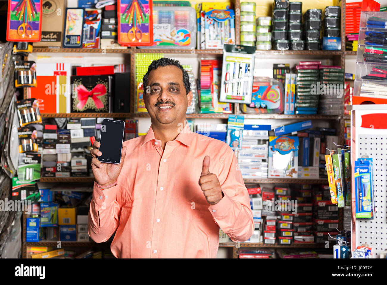 1 Indian Shopkeeper Man Showing Thumbs up With Cell Phone In Stationary ...