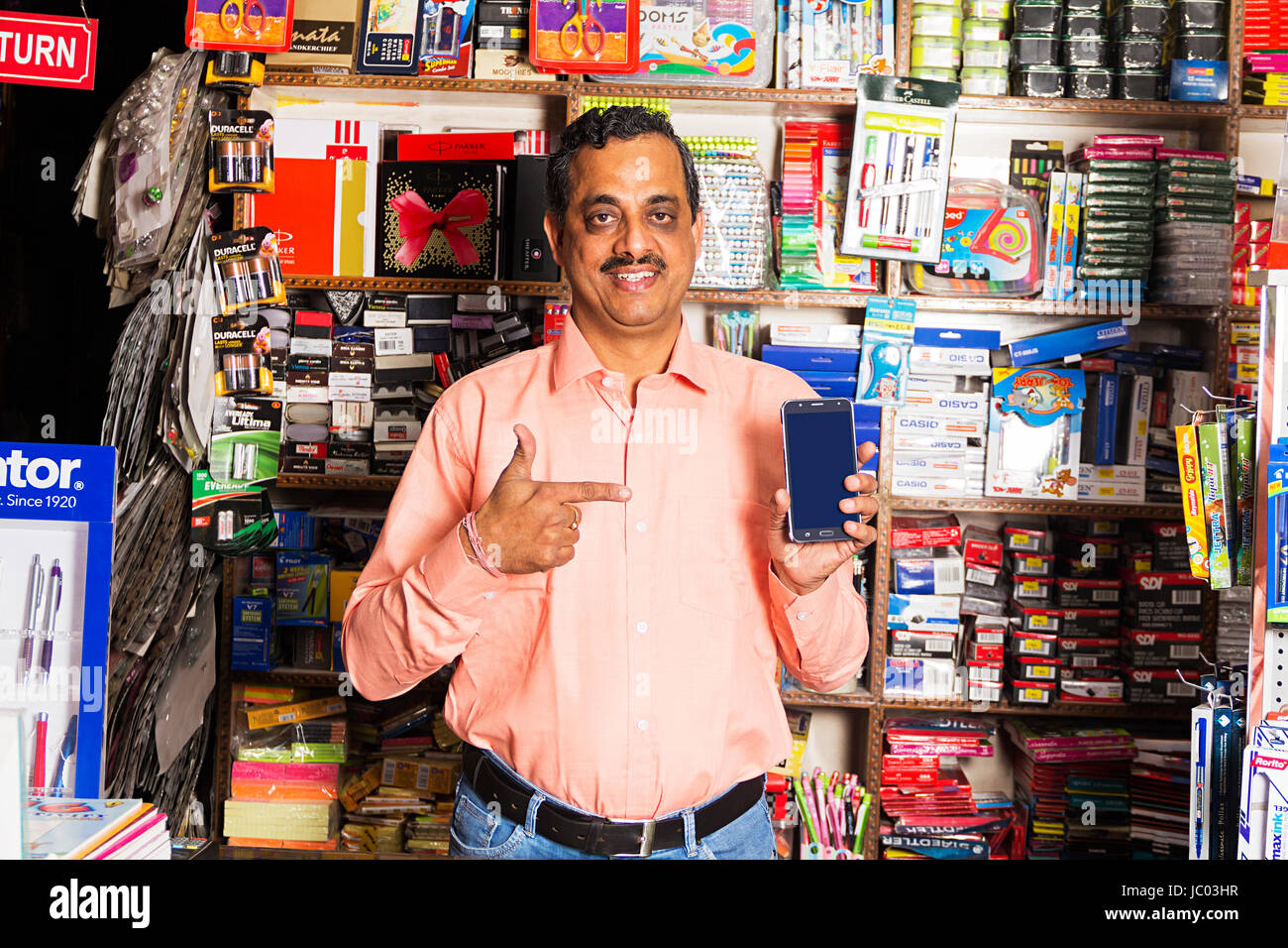 1 Indian Shopkeeper Man Finger Pointing Showing New Smart Phone In ...