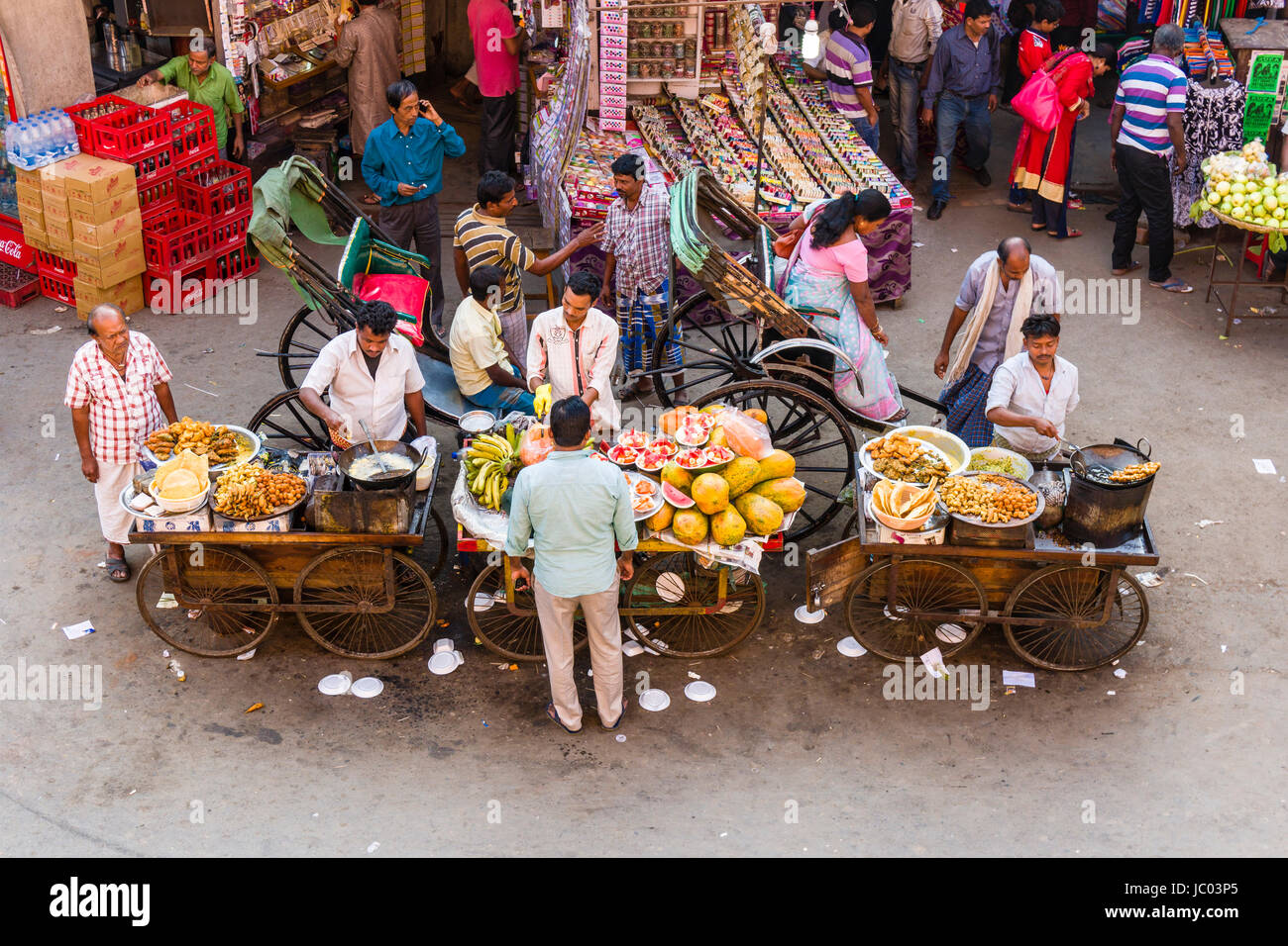 A man is selling fruits on a busy vegetable market street in the suburb ...