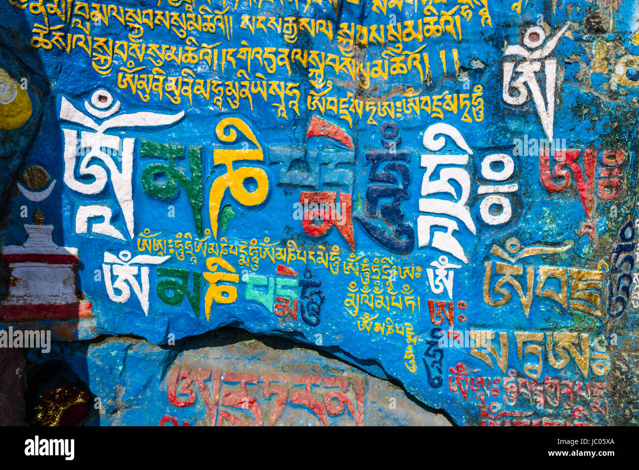 The tibetan mantra Om Mani Padme Hum is carved out of a rock and ...