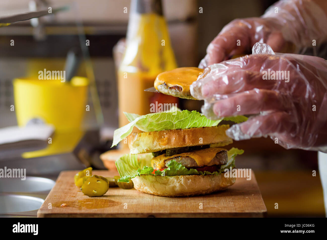 Making Homemade Maxi Burger with grilled beef steak, lettuce, cheese ...